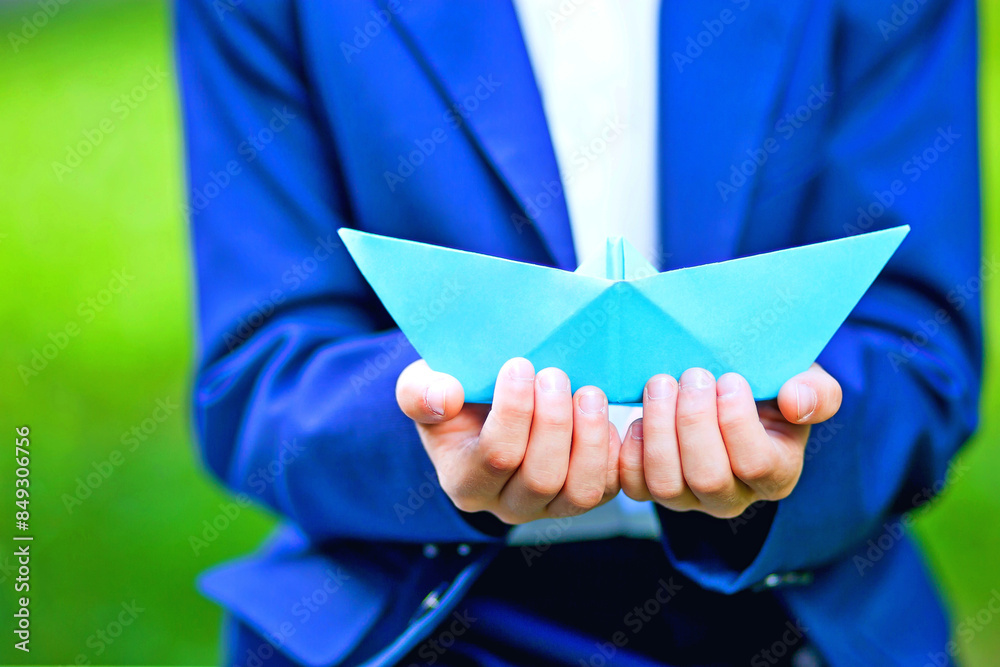 Child hands holding blue ship - symbol getting knowledge at school ...