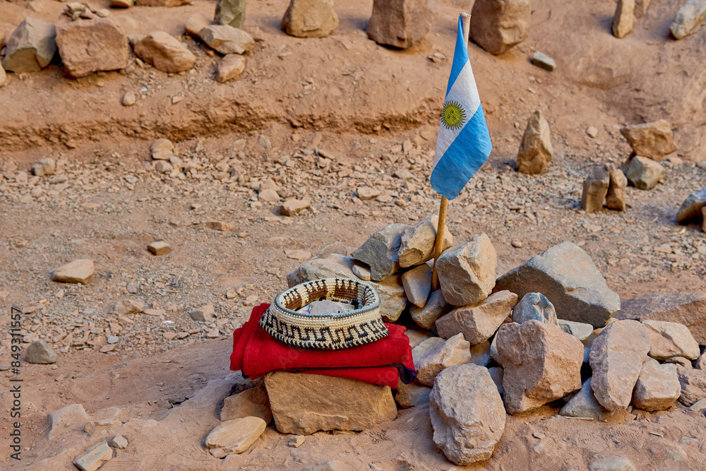 small argentine flag on rocks next to a handmade cap that is used to ...