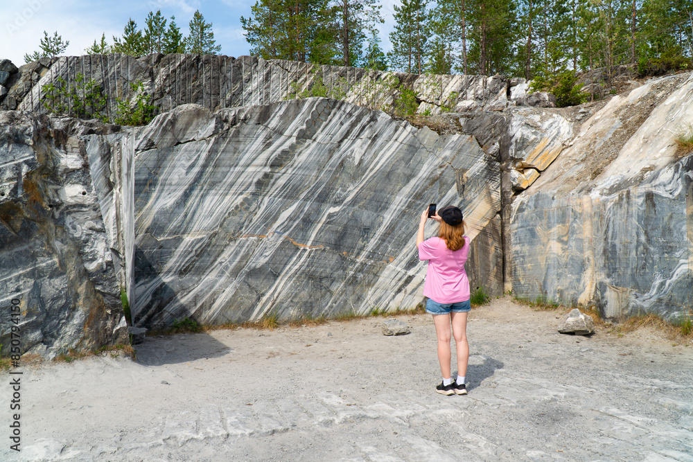 A woman capturing photos of the marble quarry's unique rock formations ...