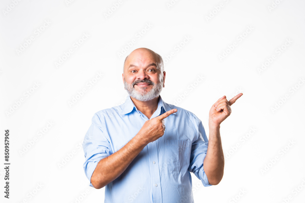Cheerful Indian asian senior retired old man pointing finger at blank ...