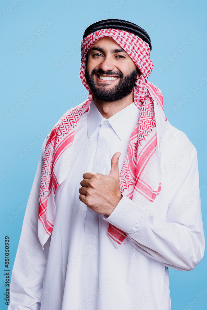 Smiling arab man in traditional robe and headdress showing thumb up ...