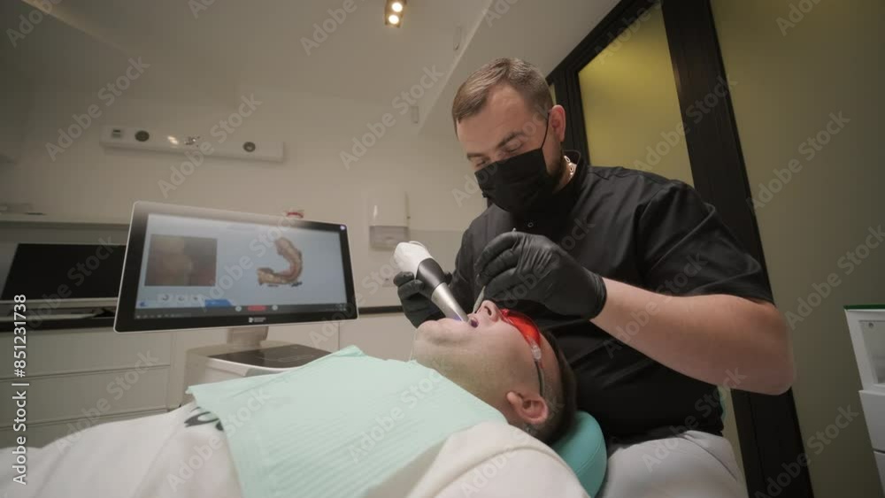 Doctor scans the patient's teeth in the clinic. The dentist holds in ...