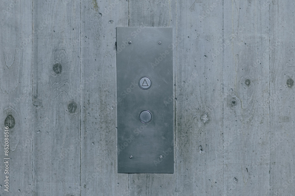Button of a passenger lift or elevator on interesting concrete wall ...