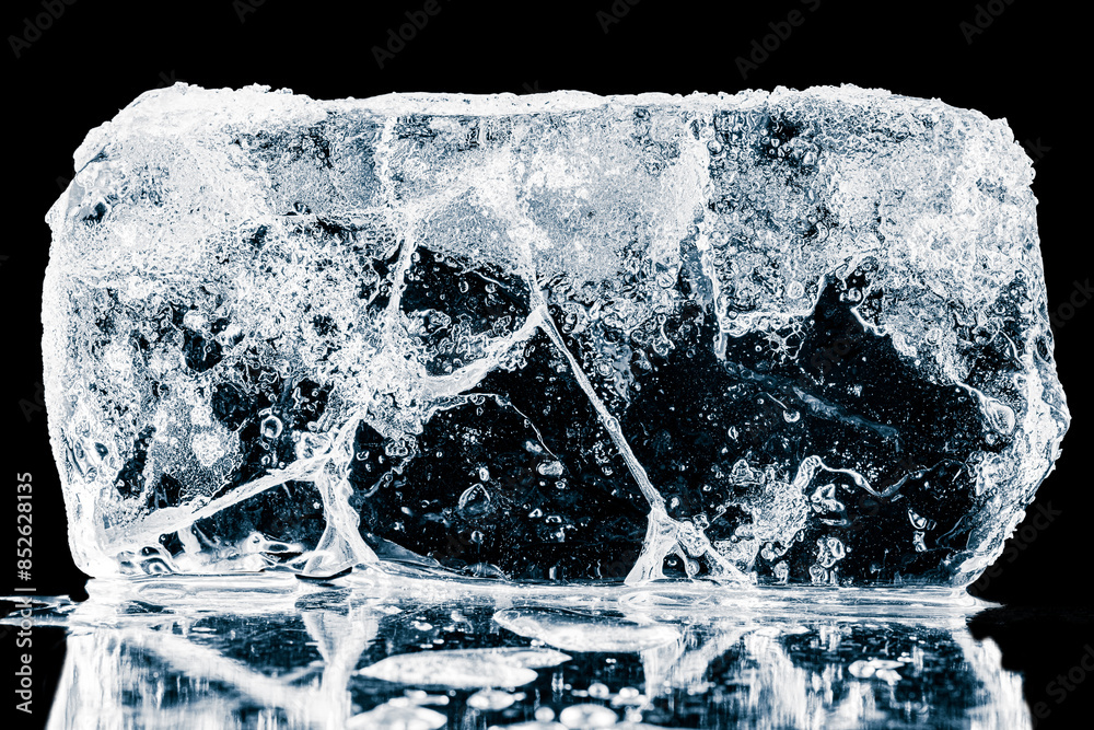 Crystal clear textured natural ice block with cracks on a black ...