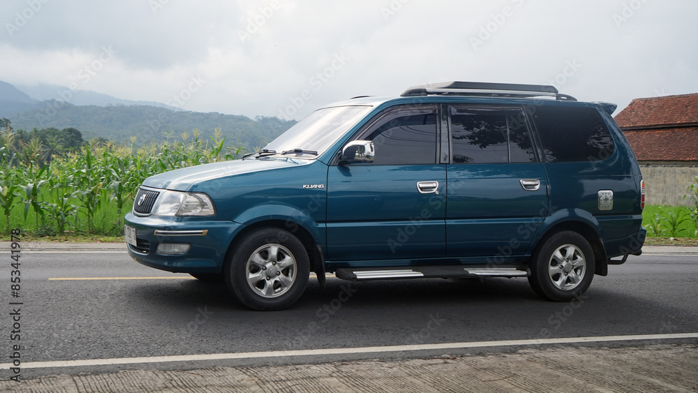 D Dark green color MPV car, Toyota Kijang, drive with background ...