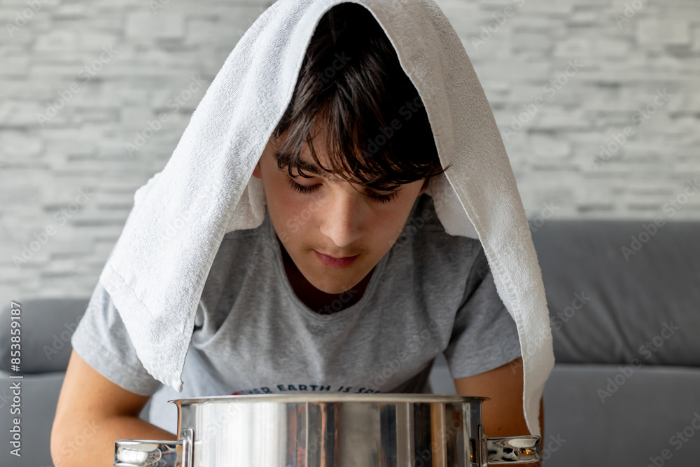 Teenage boy, child, doing steam inhalation at home to soothe and open ...