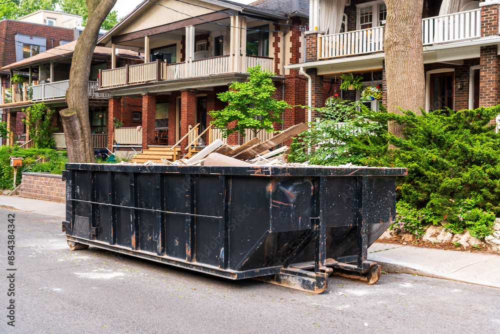 A roll-off construction dumpster filled with broken plaster and lath ...