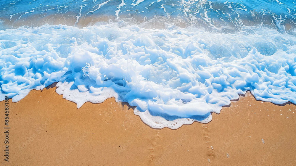 blue ocean waves washing up on a sun-kissed beach, captured from a ...