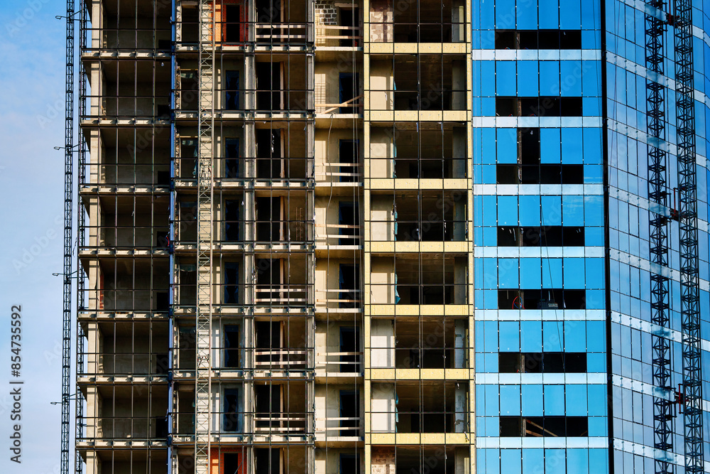 Building under construction, precast glass facade panels installation, warming exterior walls ...