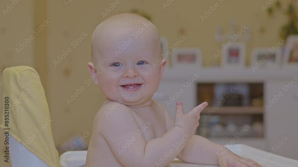Baby boy smile in high chair, showcase first teeth, yellow background ...