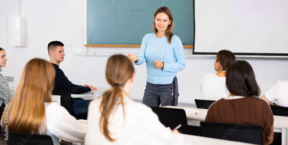 Female teacher teaching high school students in a school classroom ...