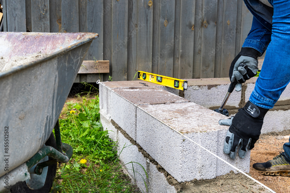 Construction worker laying expanded clay blocks. Foundations of a house ...