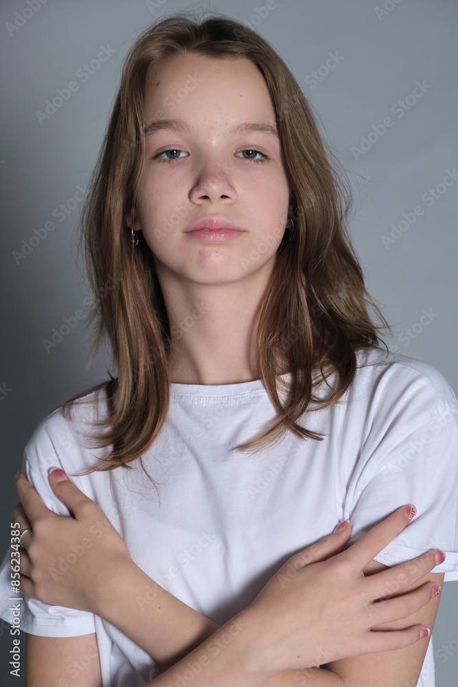 A Teenage Girl Stands With Her Arms Crossed Gazing Intently Into The