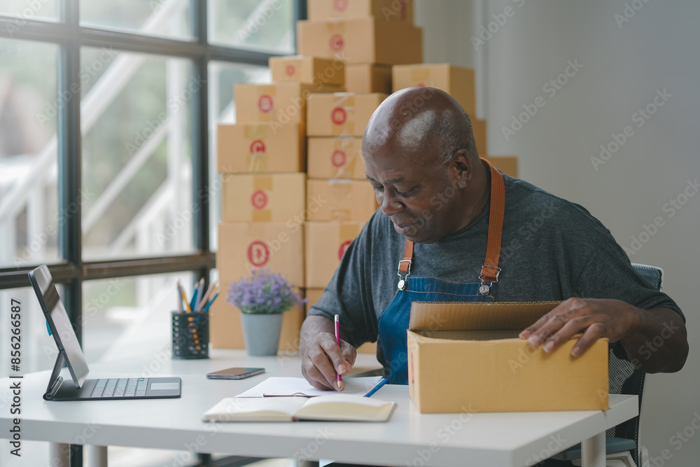 Man packing boxes in a home office. Small business owner preparing ...
