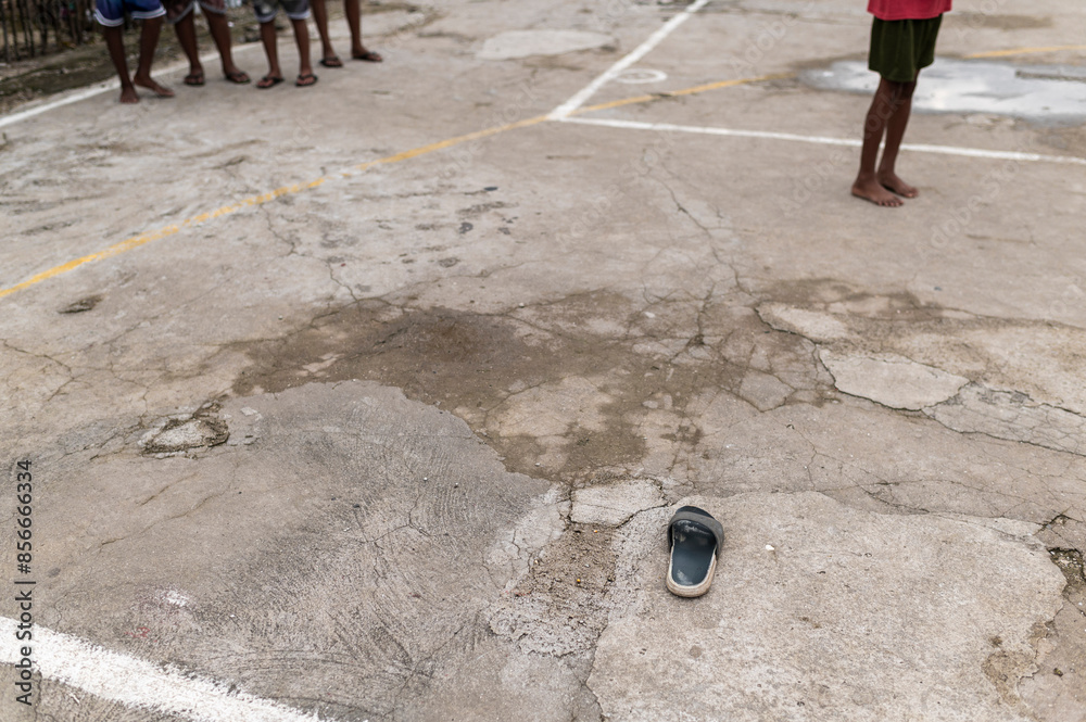Filipino children standing on worn basketball court with a single ...