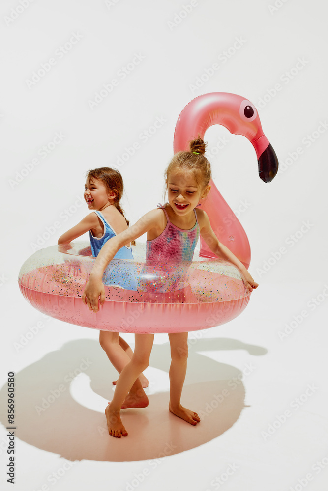 Little girls posing standing. joyfully plays together in inflatable ...