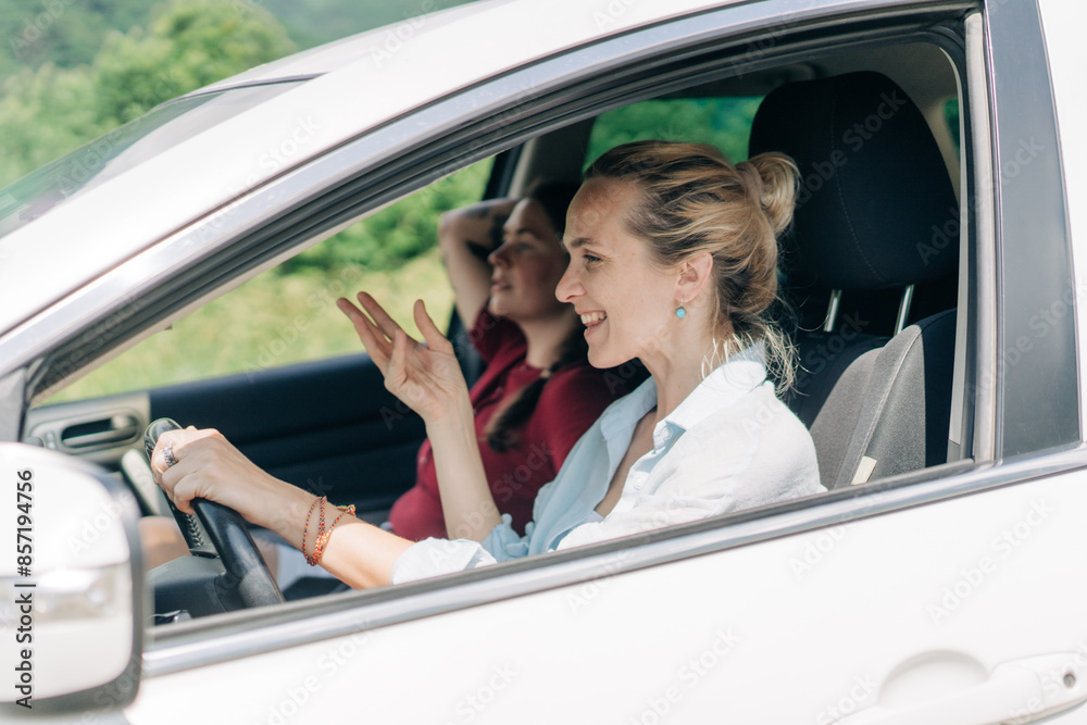 Two Women Are Driving Along The Road In A Car On A Road Trip Stock
