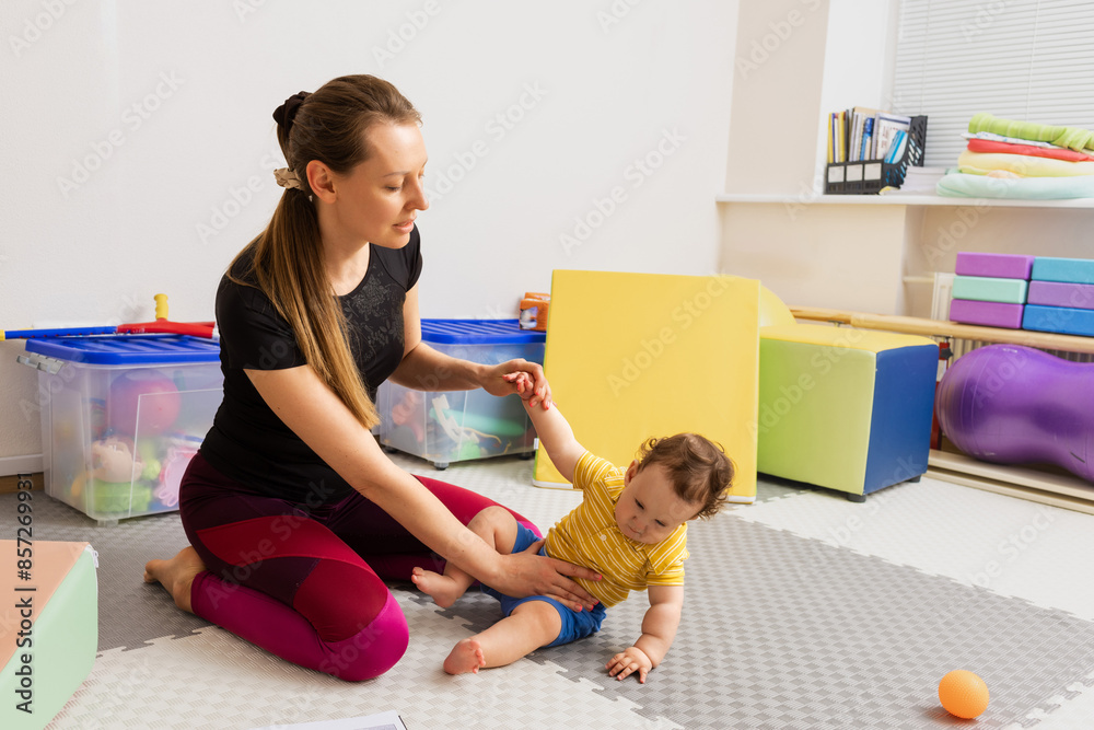 Poster Physiotherapist testing little baby for presence of reflexes and ...