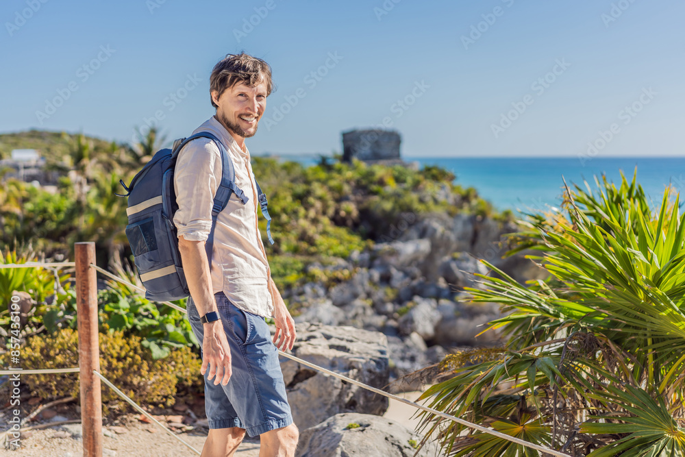 Man tourist enjoying the view Pre-Columbian Mayan walled city of Tulum ...