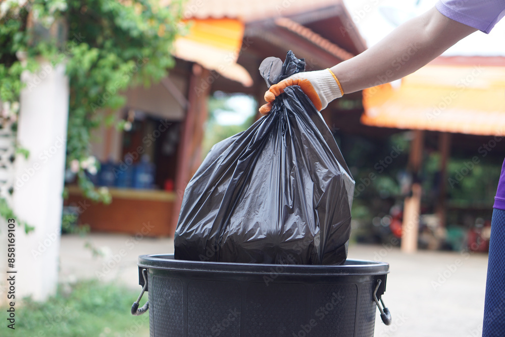 Hand holding garbage black bag putting in to the bin. Concept, garbage ...