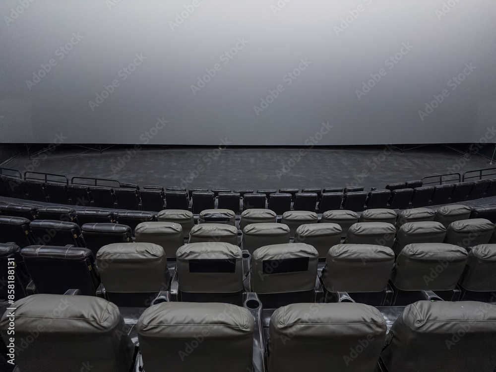 This image captures an empty IMAX cinema hall with multiple rows of ...