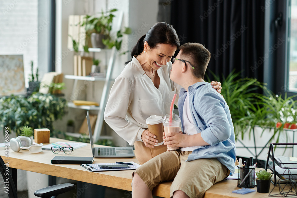 Foto de A mother smiles warmly at her son, who has Down syndrome, while she works in her office ...