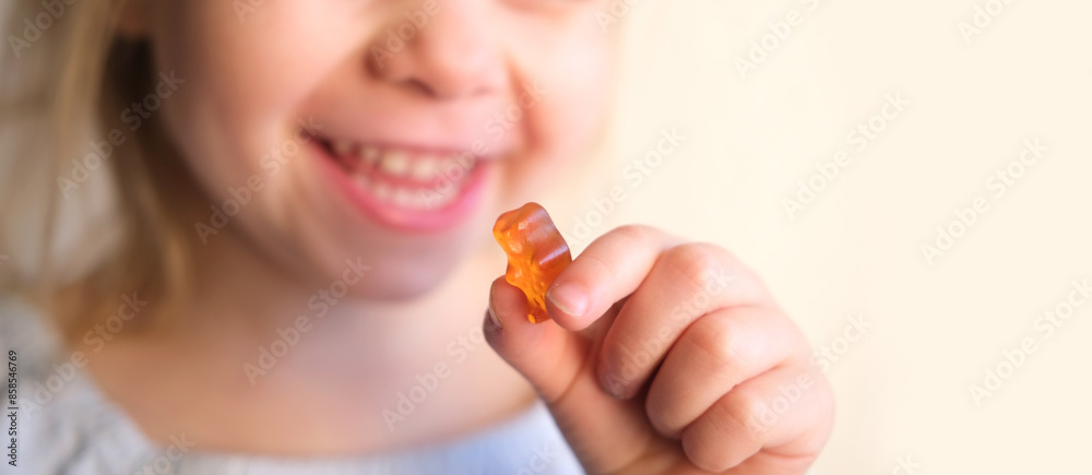 small child, blonde girl 3 years old wants to eat gelatinous sweets ...