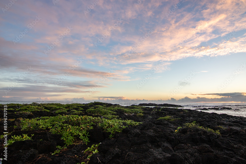 Sunrise over the sea with light waves. Sand beach with lava rocks and ...
