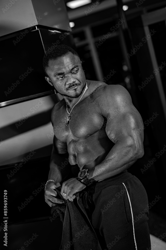 Muscular Man Posing in Gym. A muscular man in a gym stands shirtless ...