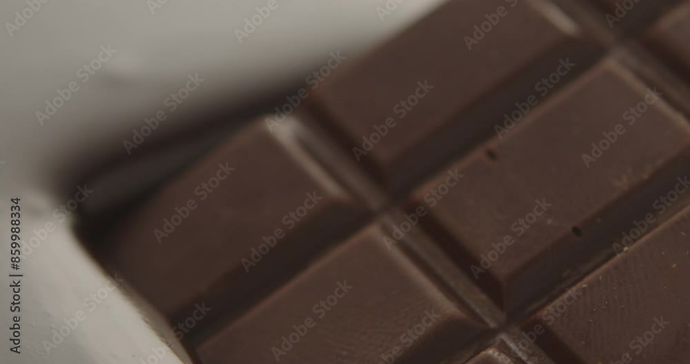 Closeup footage of dipping a chocolate bar in the melted chocolate ...