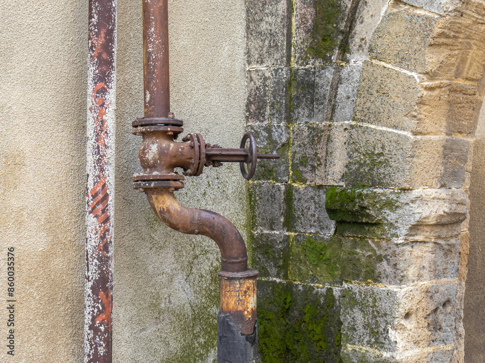 An old pipeline running outside the old building. Pipes with fittings ...
