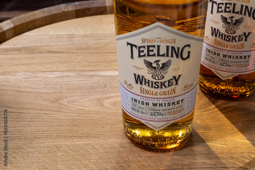 Bottles of Irish whiskey Teeling Single Grain on oak barrel background ...
