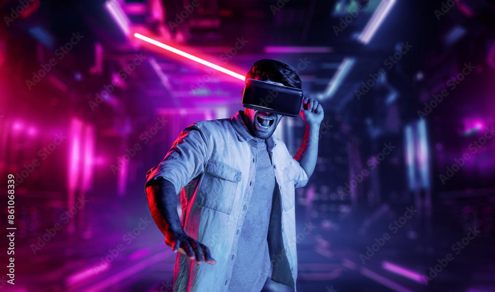 Gamer holding laser sword and playing action game while wearing VR ...