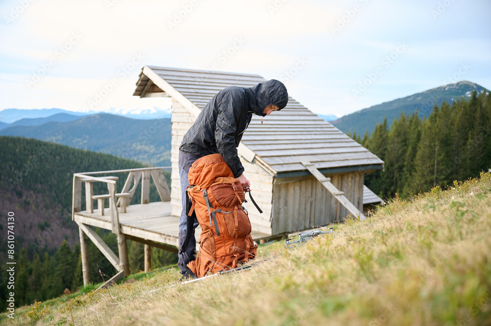 Fully equipped hiker talking by walkie-talkie on the peak of the ...