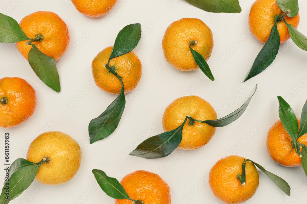Bright, fresh tangerines with green leaves on neutral background ...