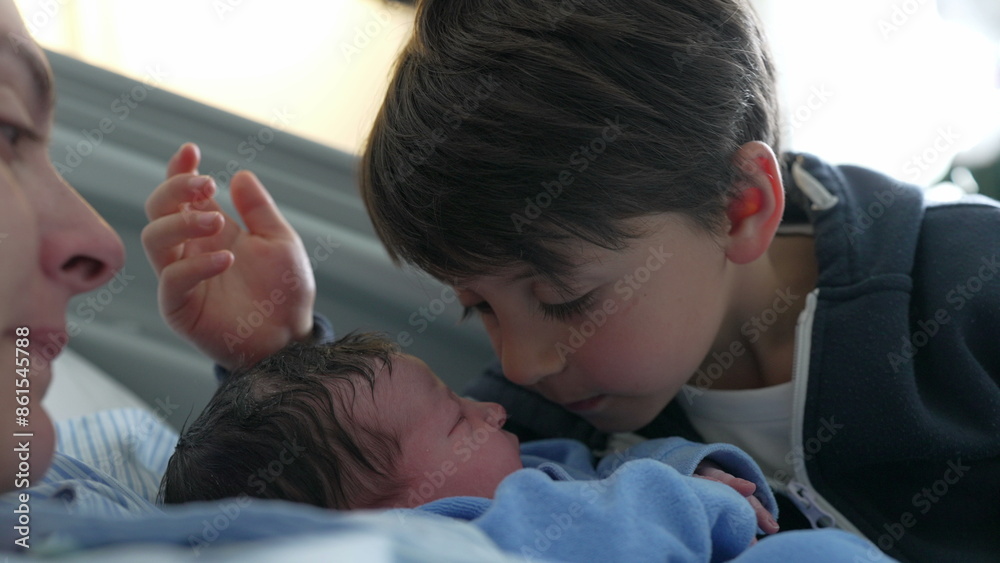 Young boy meeting his newborn baby brother for the first time at ...