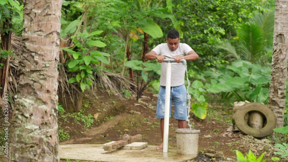 Young southeast asian farmer collecting rainwater in groundwater tank ...
