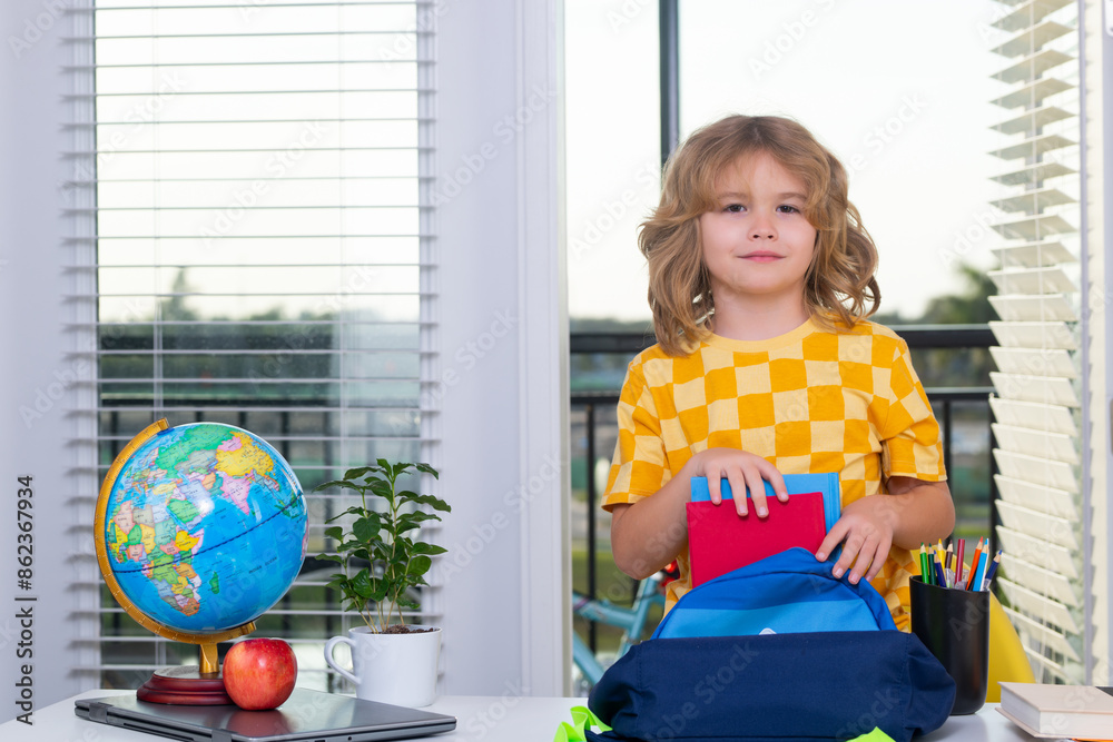 Child school boy to do homework at table in room. Portrait of nerd ...