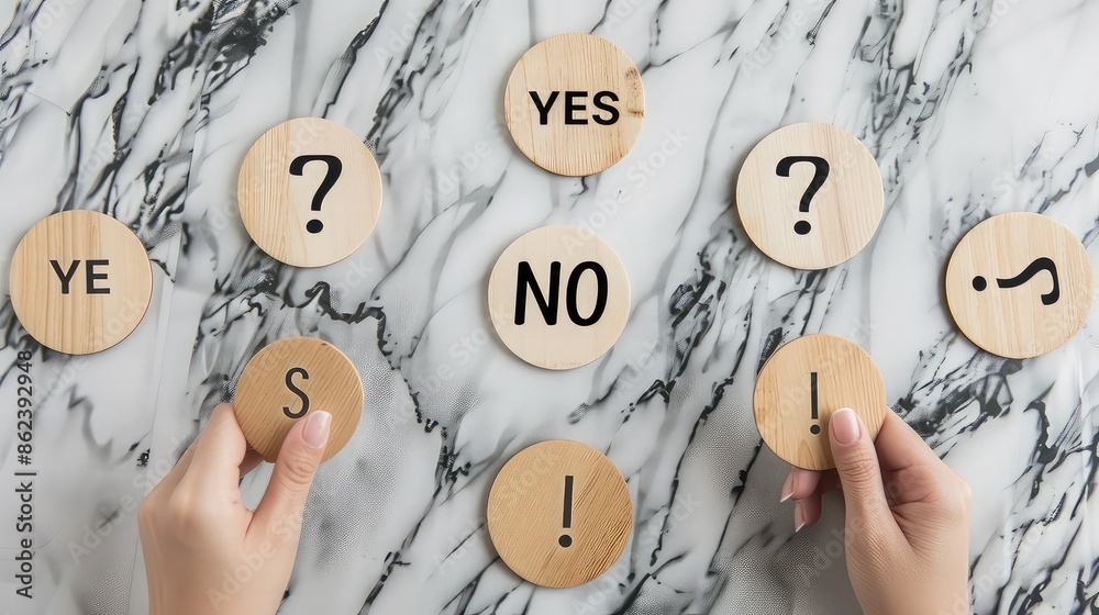 Person displaying wooden discs labeled "YES" and "NO", question marks ...