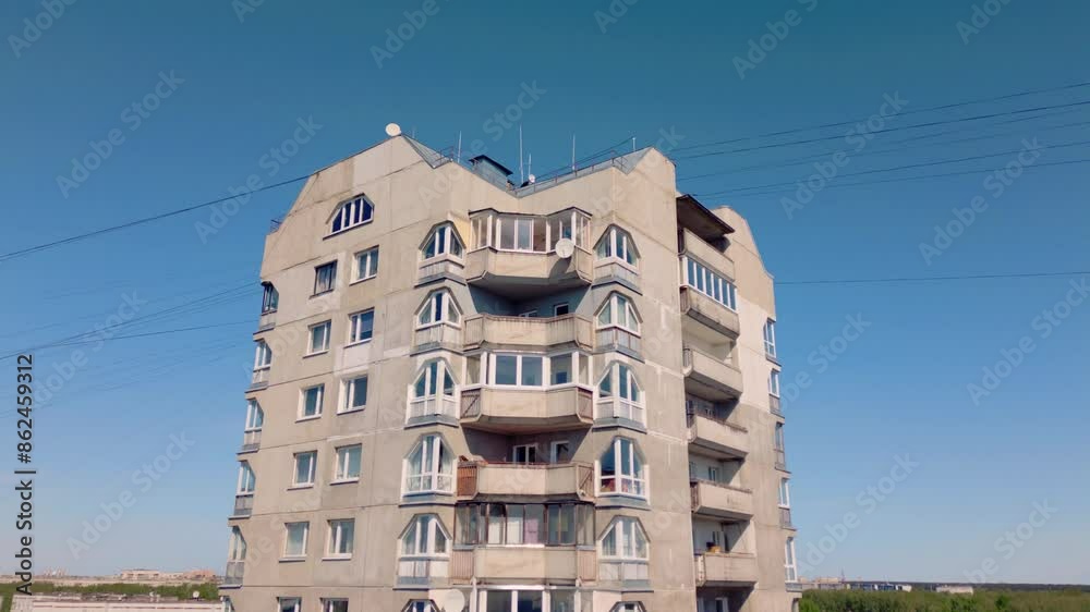 Drone footage ascends past a high-rise grey Soviet apartment block in ...