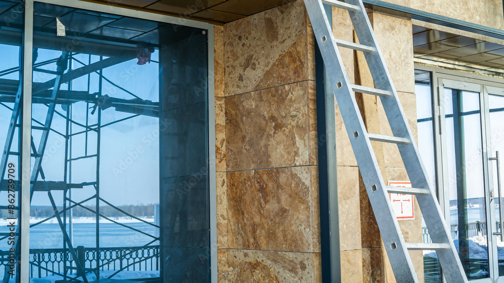 An aluminum alloy construction ladder is attached to the wall for ...