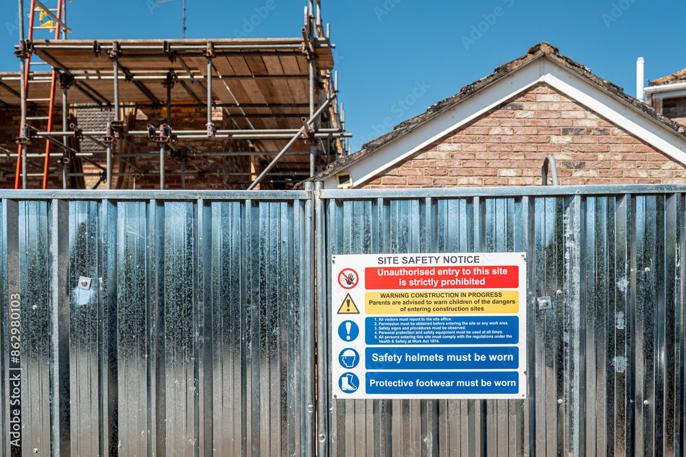 Newly erected Site Safety Notice attached to a shiny metal barrier. A ...
