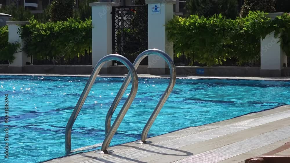 Blue swimming pool with metal ladder leading into water. Perfect for ...