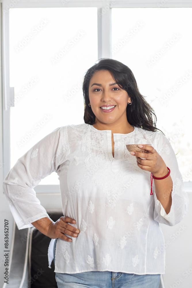 beautiful mexican woman toasting with shot of tequila or mezcal holding ...