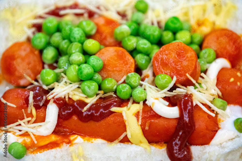 Traditional Brazilian style hot dog with sausage, peas and straw ...