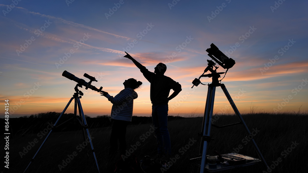 Amateur astronomers looking at the evening skies, observing planets ...