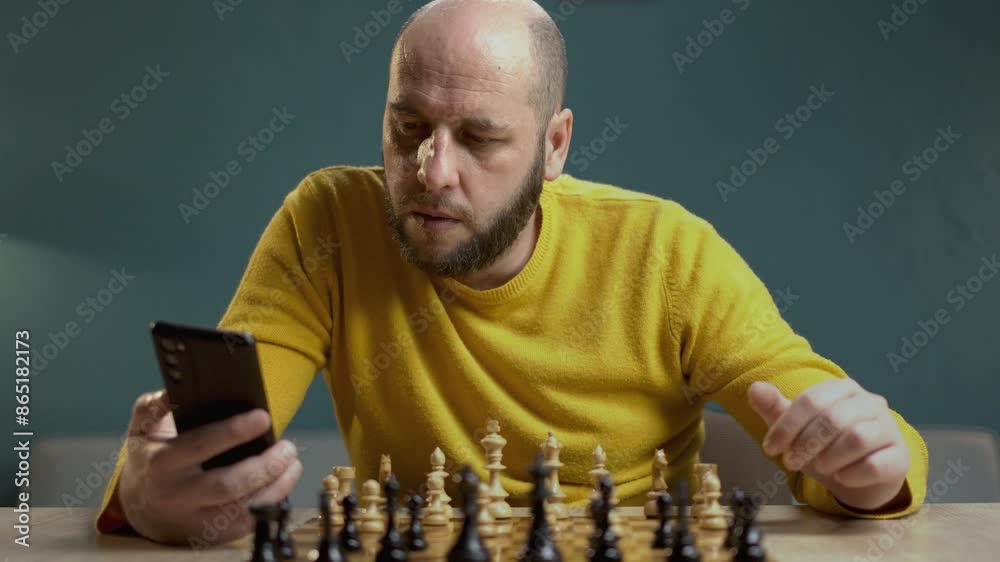 Handsome man plays chess. Online learning, hobby. Chess and gadget ...