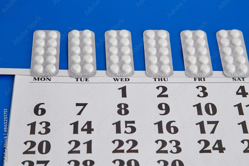 Blisters of white and red pills, arranged like days of the week on a ...
