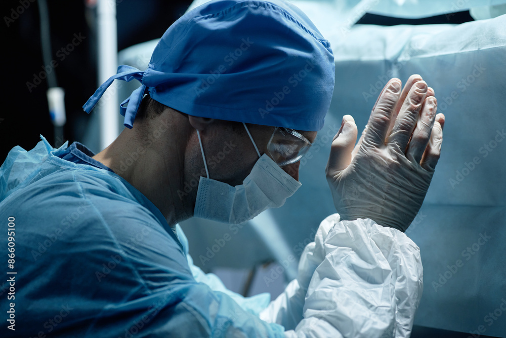 Side view portrait of male surgeon wearing mask and full protective ...