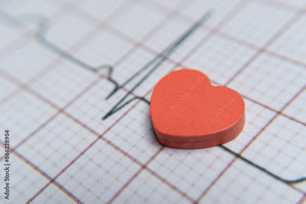 Closeup image of a red heart on a electrocardiogram (ECG) printout. The ...
